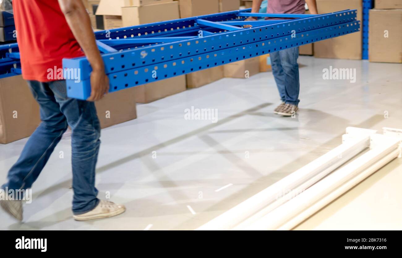 Two male hand preparing to assembling the metal rack in in warehouse or ...