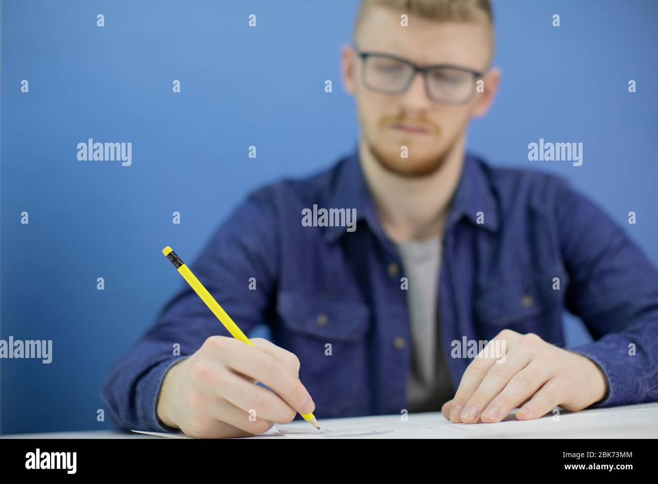 Architect at work yellow pencil in hand in focus, drawing construction ...