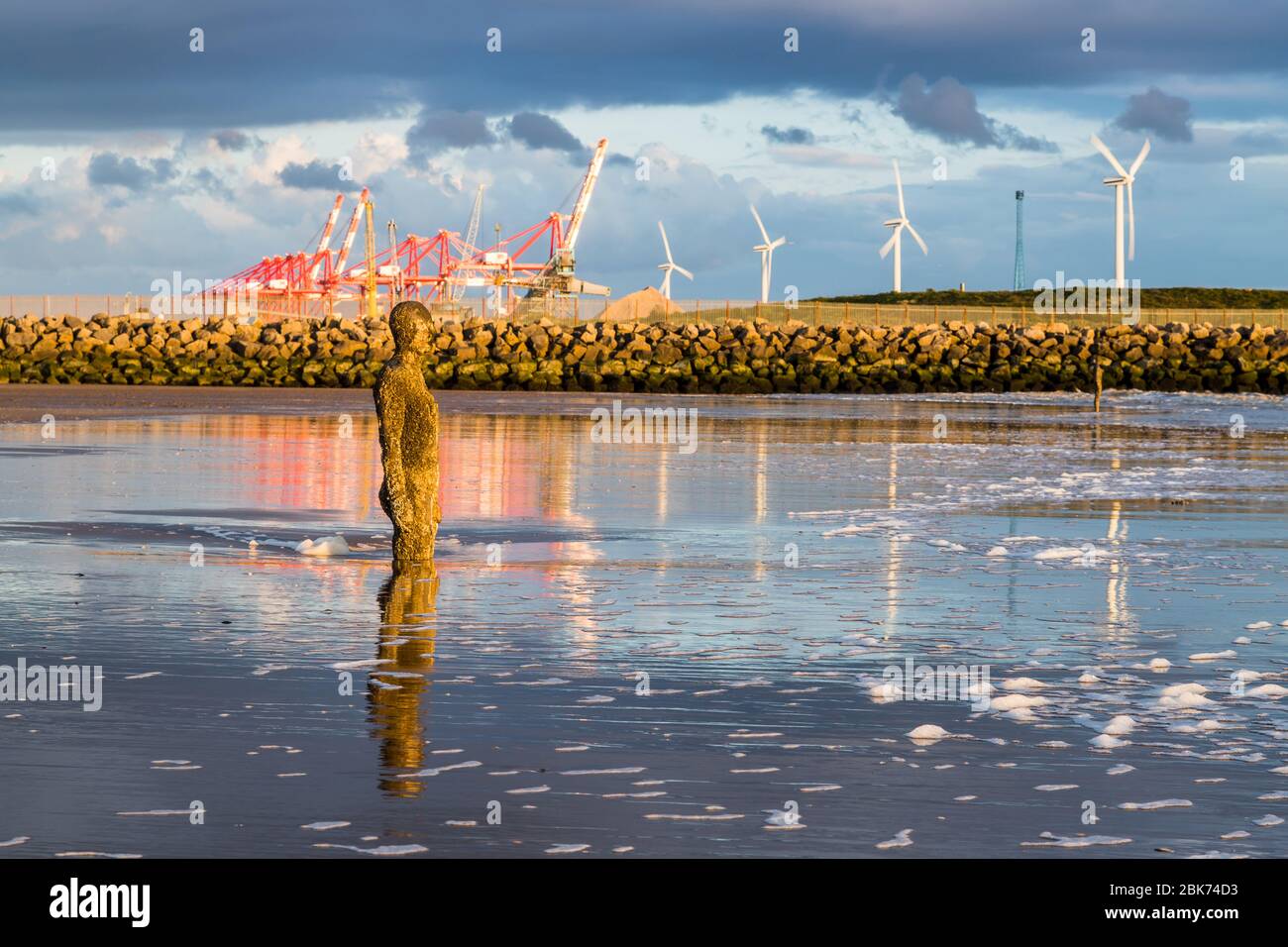 Iron Man seen in front of the Port of Liverpool on the beach at Crosby ...