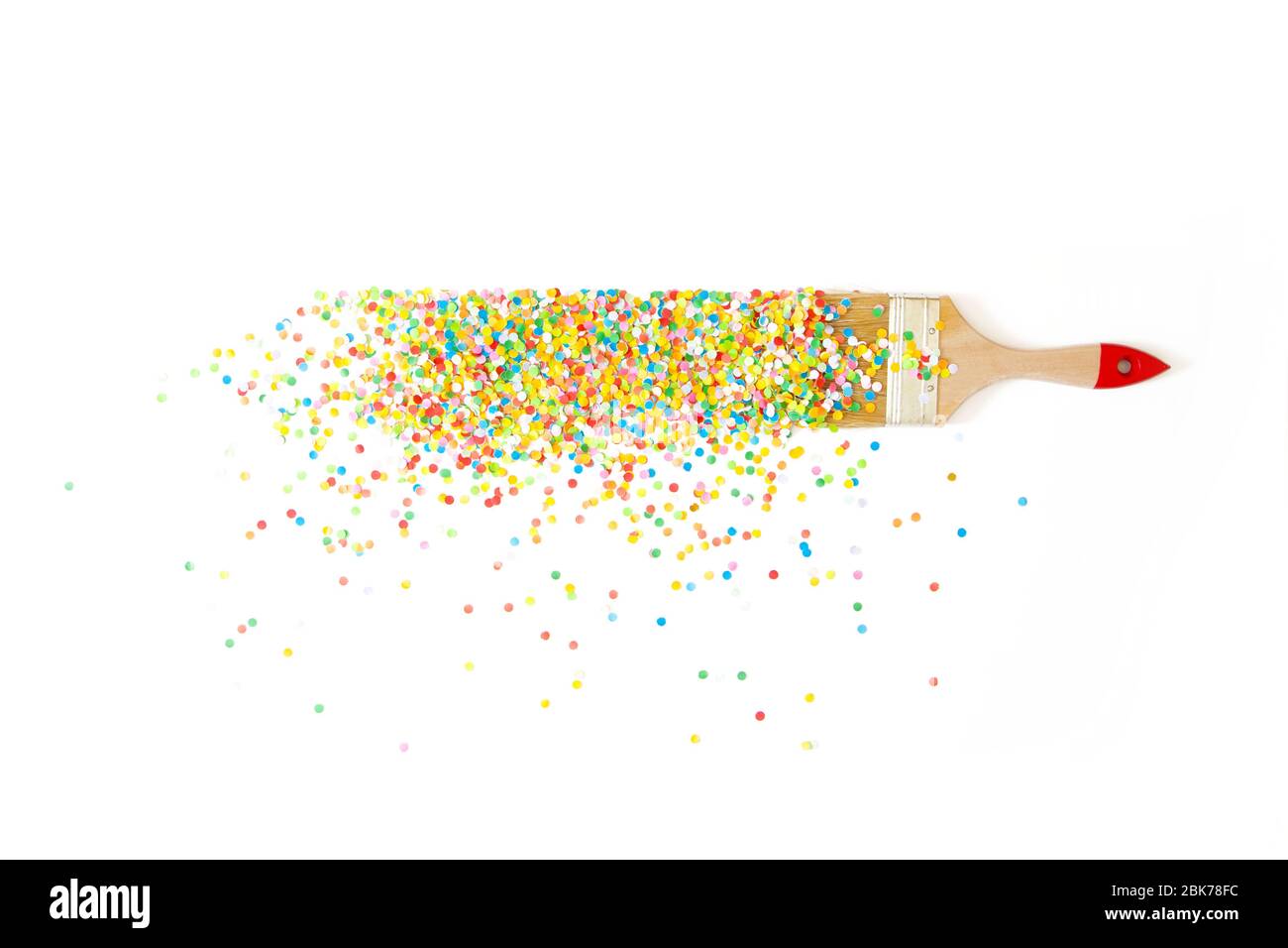 A paint brush draws a straight line with colored holiday confetti ...