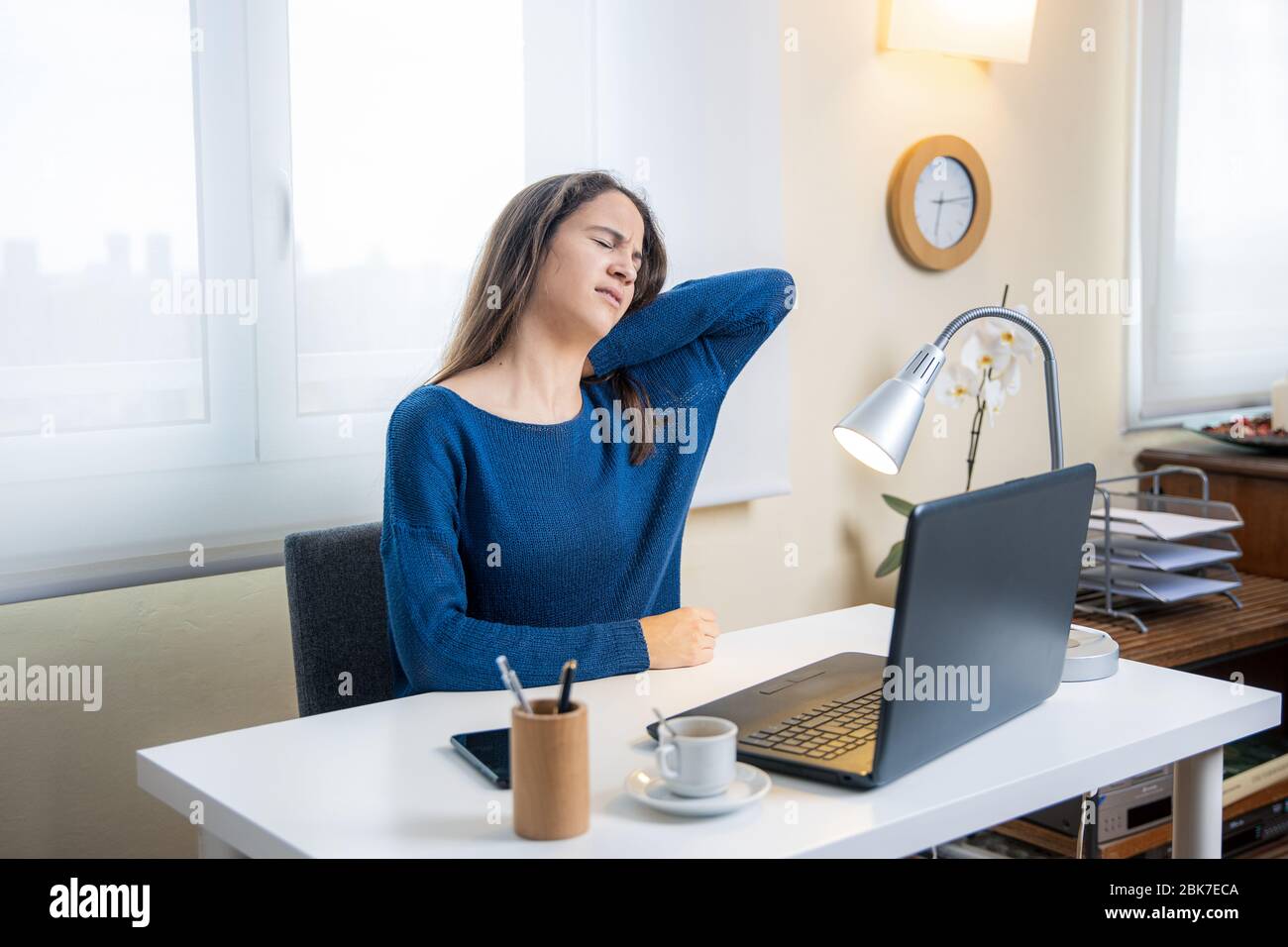 Teen student suffers neck pain with computer at home Stock Photo - Alamy