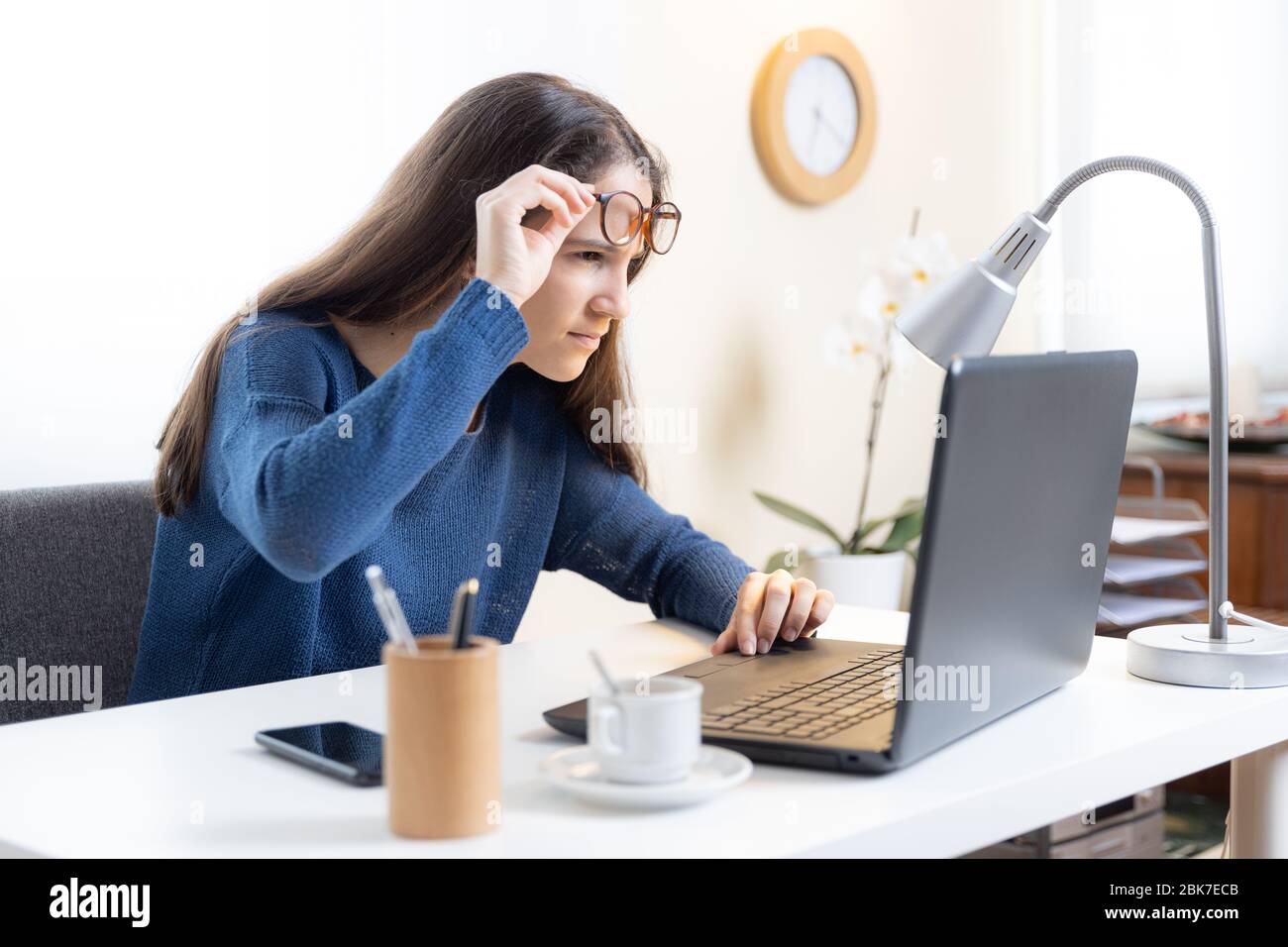 Teen girl with eyesight problems trying to study with laptop Stock ...