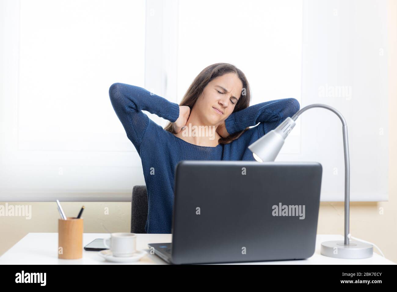 Teen student suffers neck pain with computer at home Stock Photo - Alamy