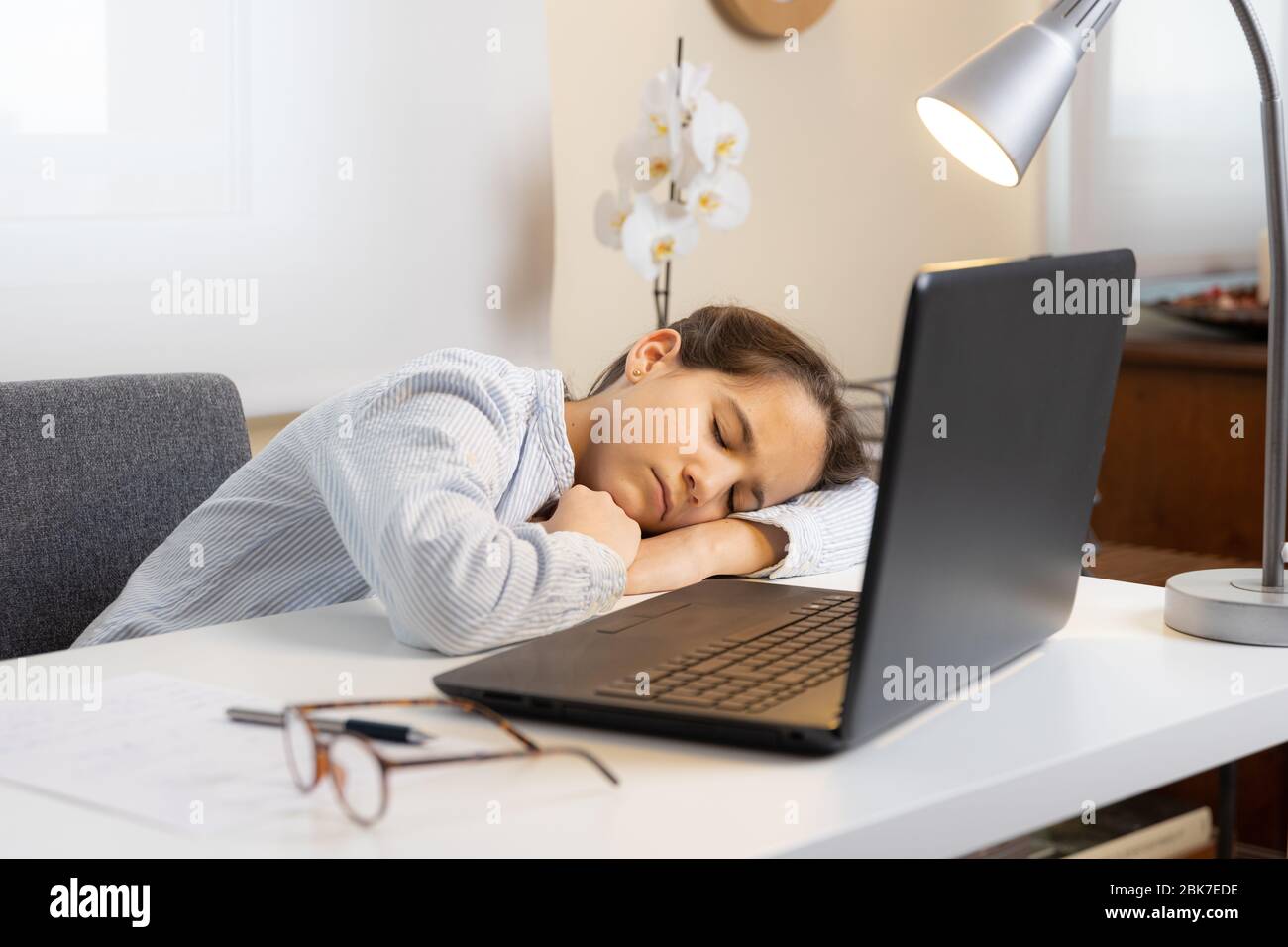 Exhausted girl asleep next to the computer Stock Photo - Alamy
