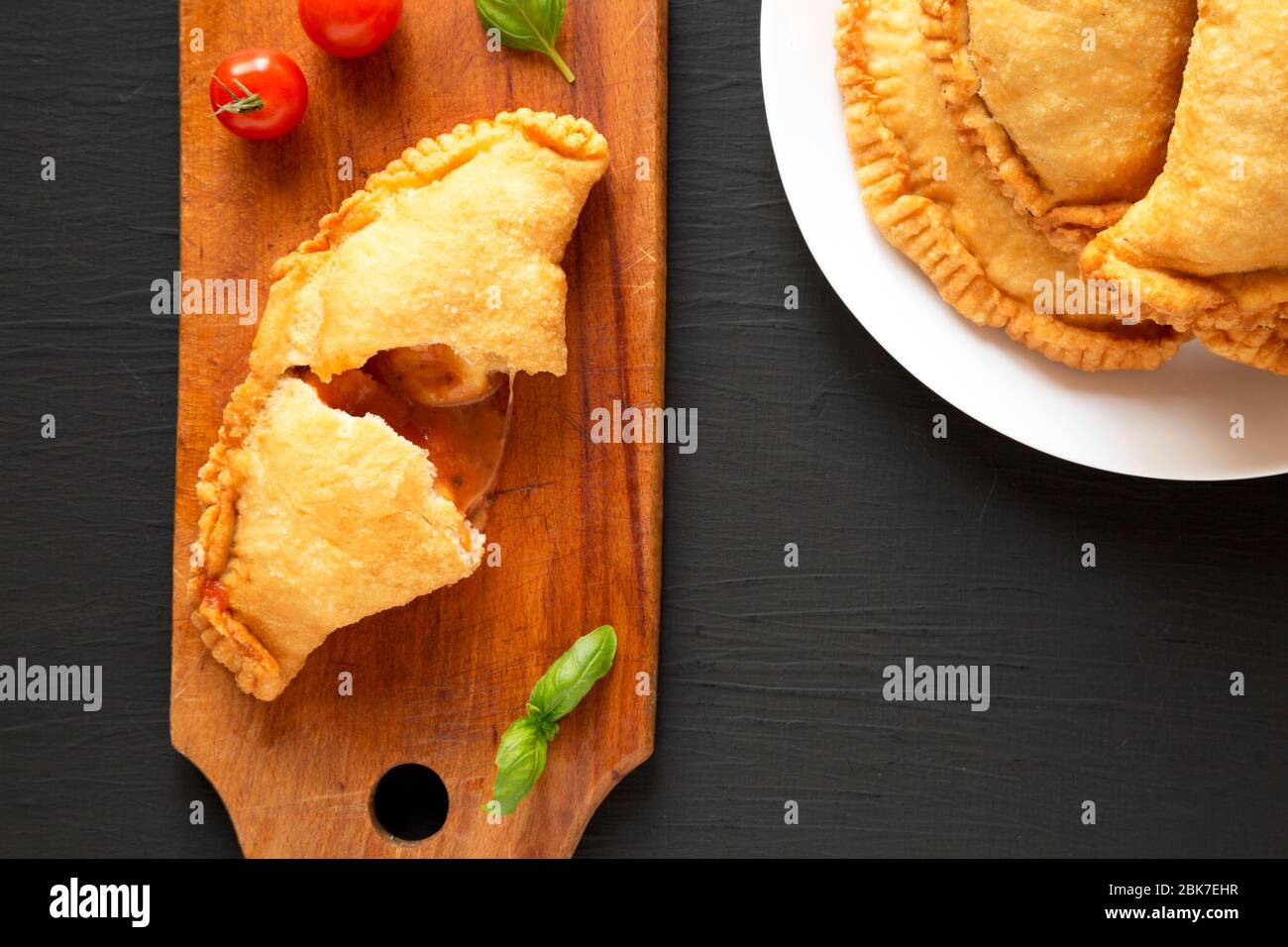 Homemade Deep Fried Italian Panzerotti Calzone with sauce on a black ...