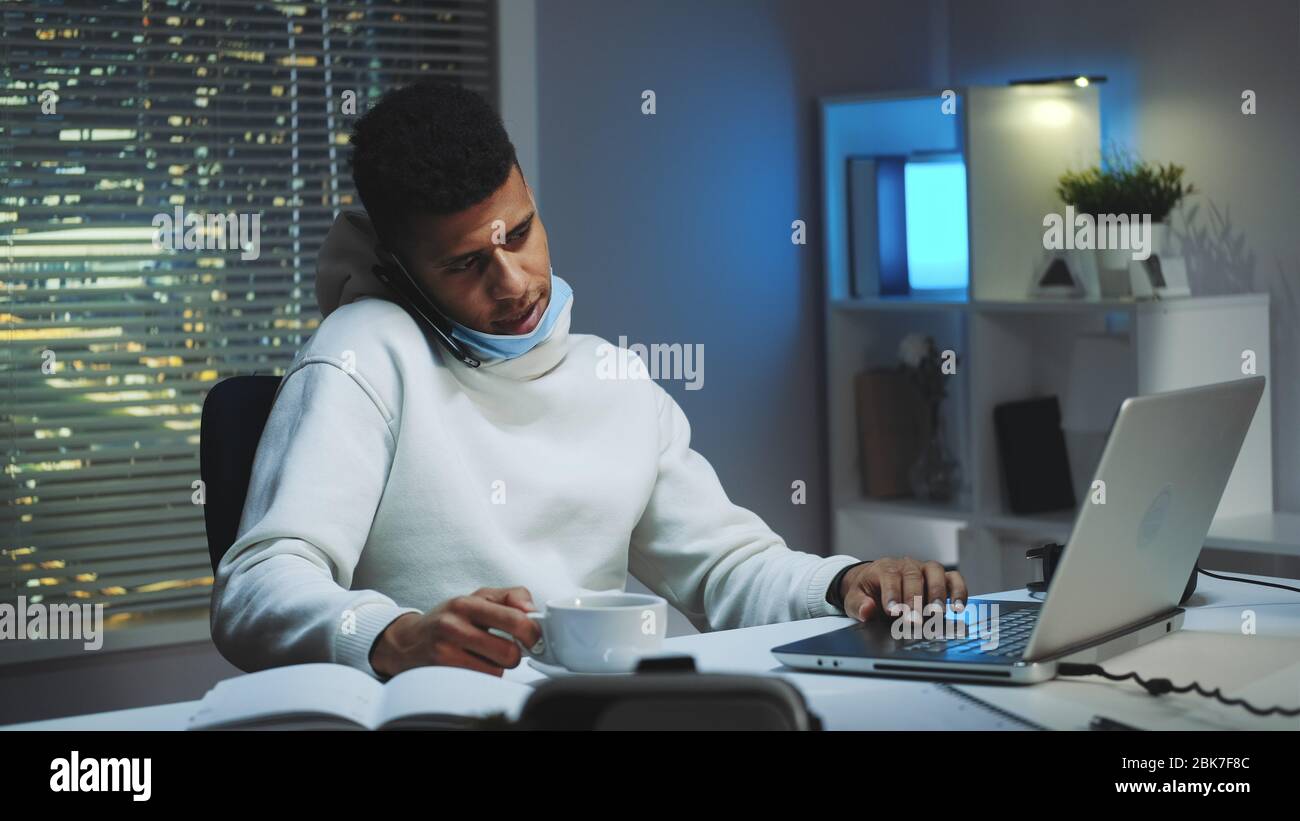 Medium shot of Mixed-race man working on computer, speaking by ...