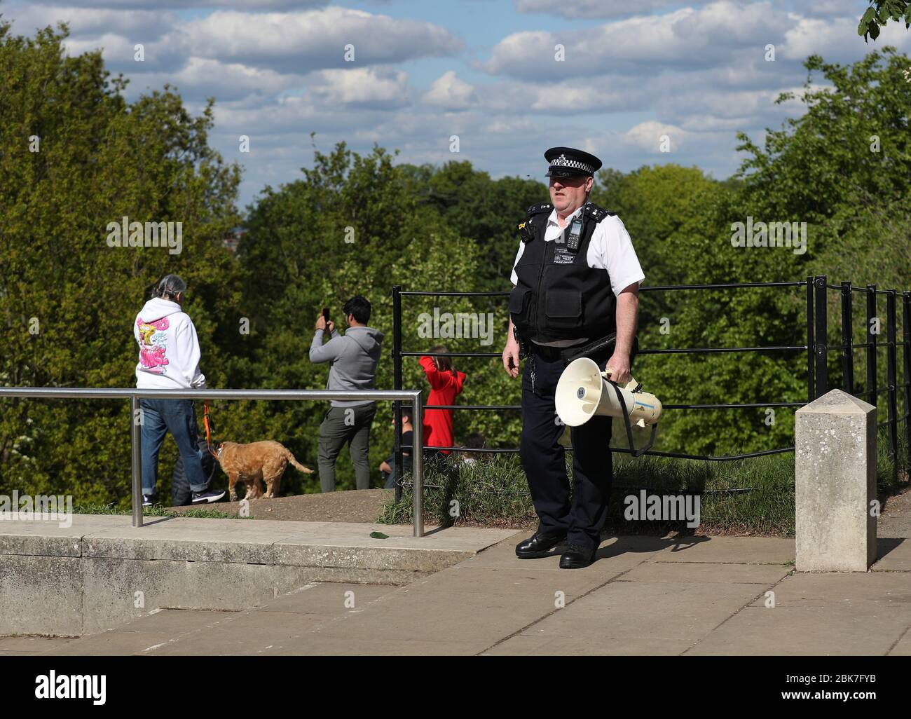 A police officer with a megaphone instructs people to keep moving in ...