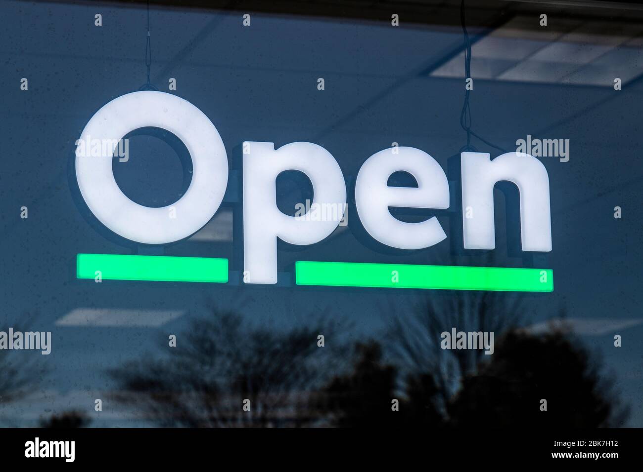 Open sign in white text and green light underline hanging in a ...