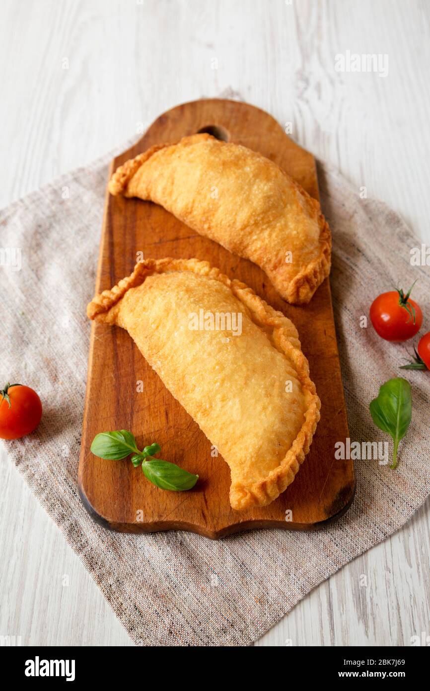Homemade Deep Fried Italian Panzerotti Calzone on a rustic wooden board ...
