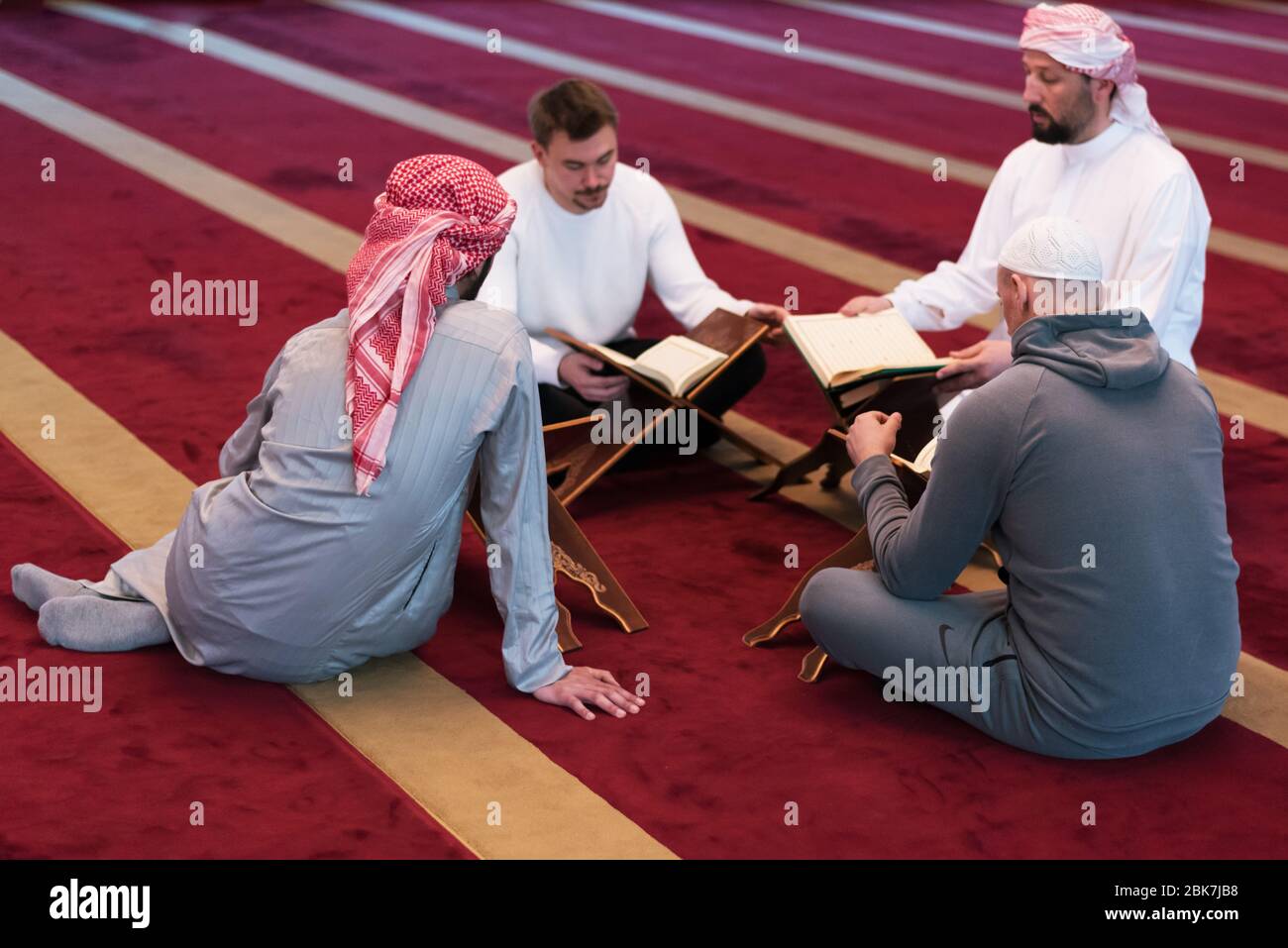 Group of muliethnic religious muslim young people praying and reading ...