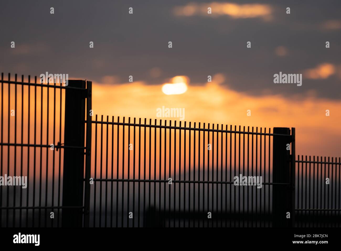 Private area fence on sunset background Stock Photo - Alamy