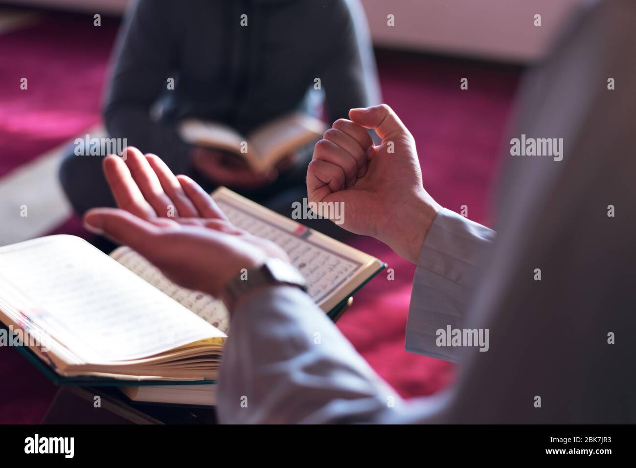 Two muliethnic religious muslim young people praying and reading Koran ...