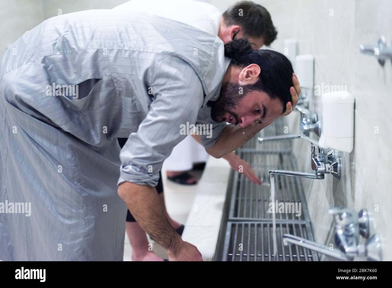 Two young Muslim people taking ablution for prayer. Islamic Religious ...