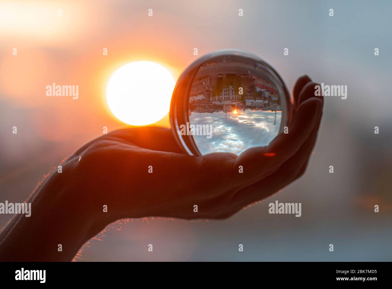 Sun and glass ball in hand, man holding crystal ball, crystal lens with ...