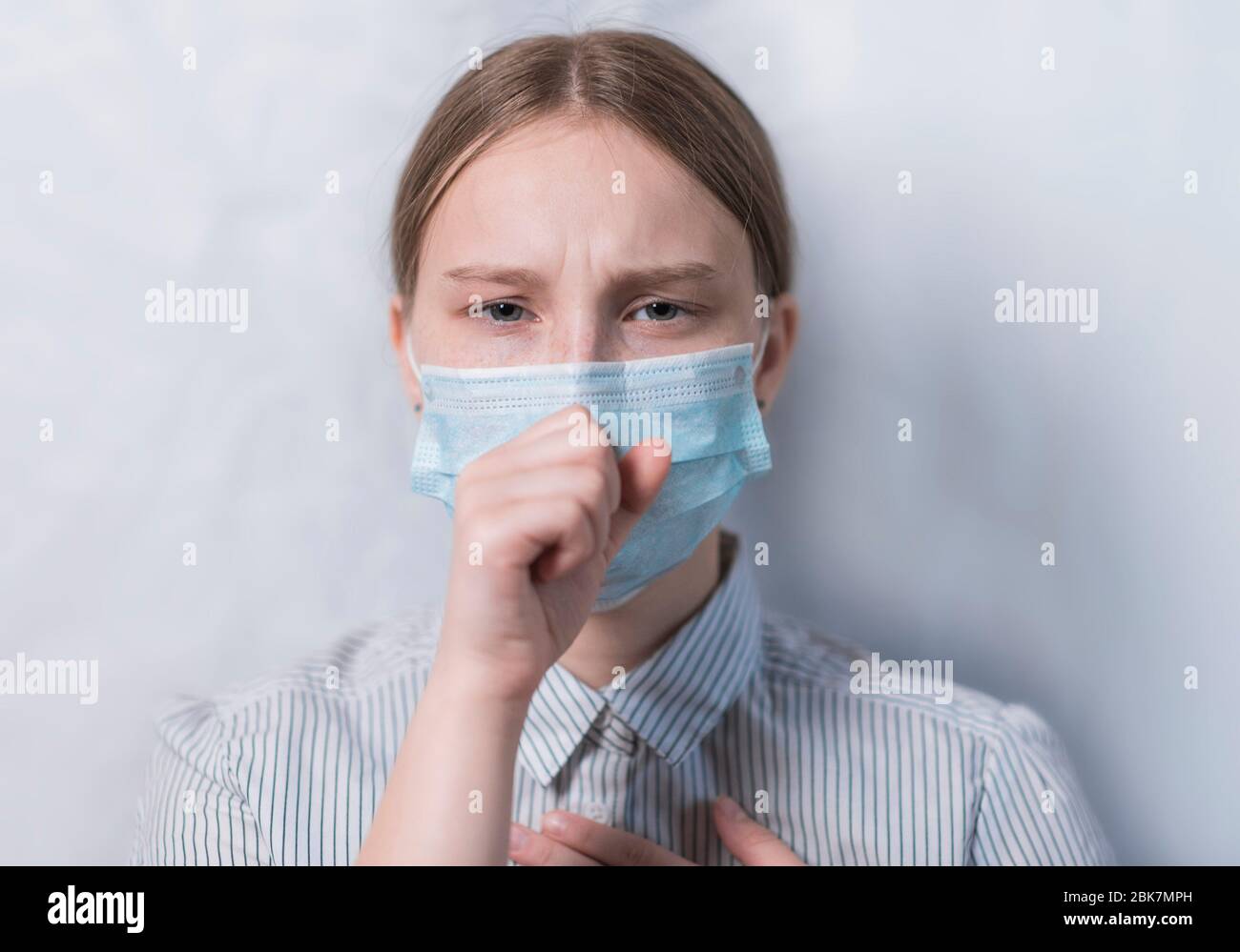 Teenager girl, protective mask, covers her mouth with her hand, cough ...