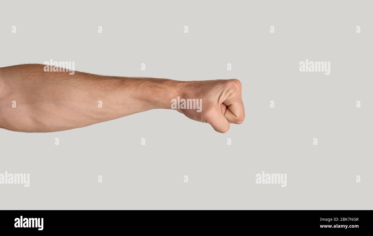 Millennial man clenching fist on light grey background, close up. Copy ...