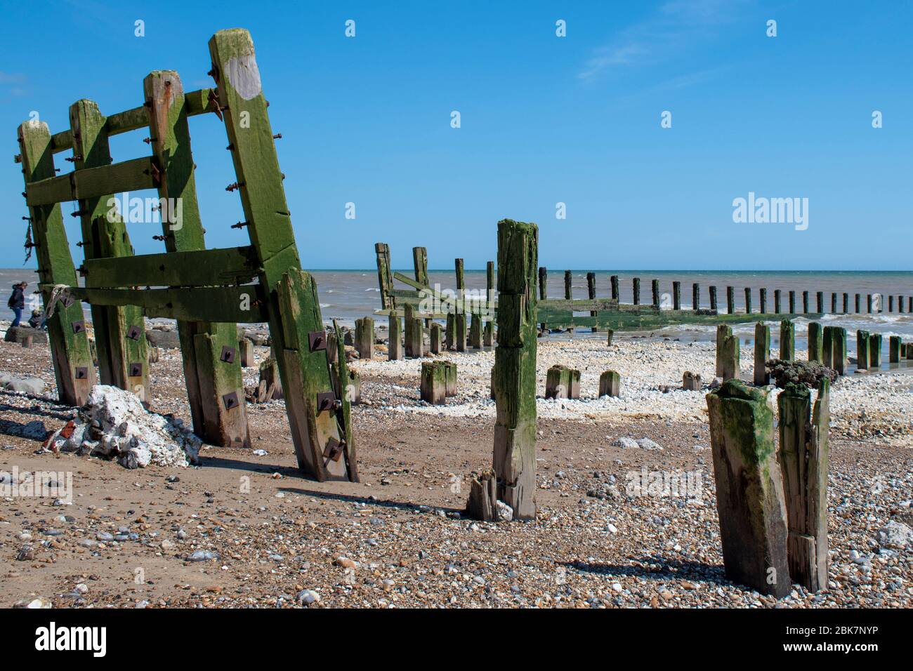 Battered wooden sea defences after winter storms on Climping Beach West ...