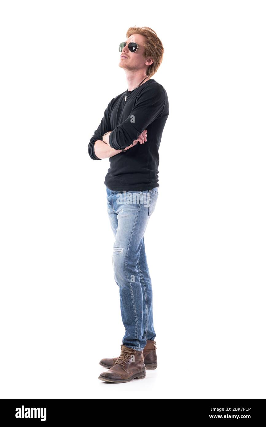 Side view of interested young handsome man with sunglasses looking up ...