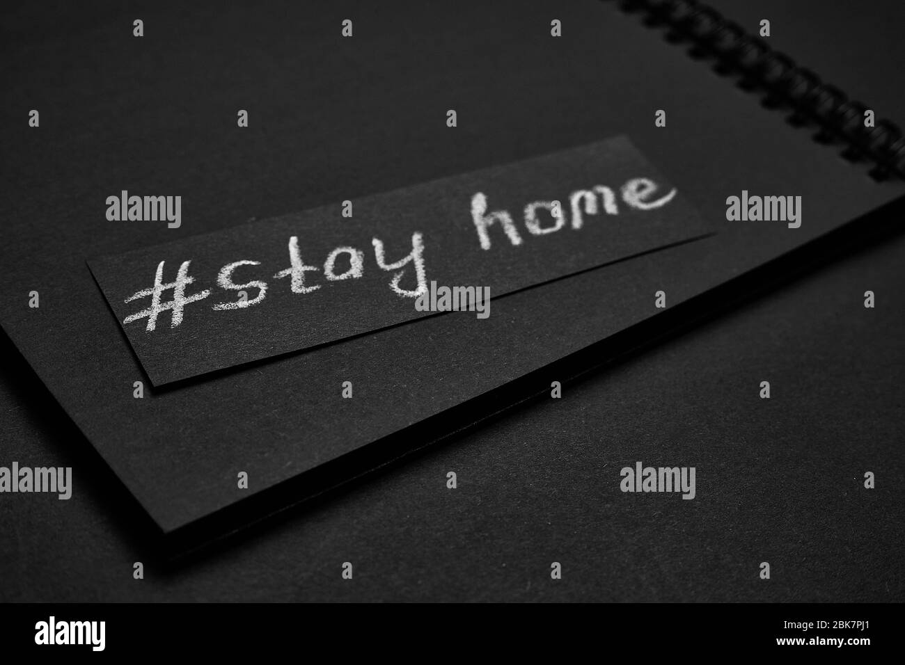 Stay at home, text. Headline inscription on black paper background ...