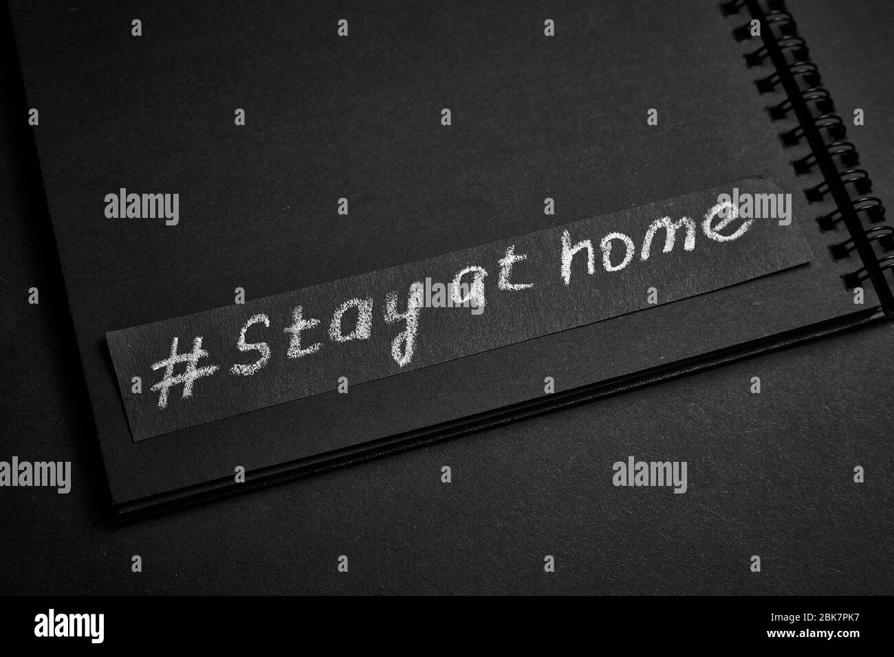 Stay at home, text. Headline inscription on black paper background ...