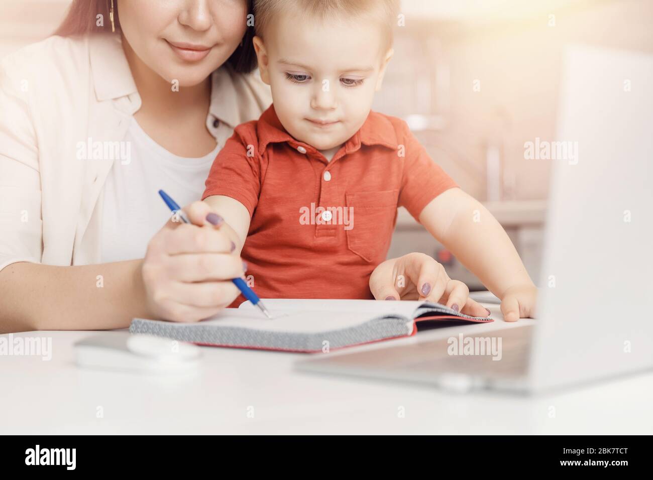 Mother and son are learning to write. Woman teaches kid alphabet Online ...