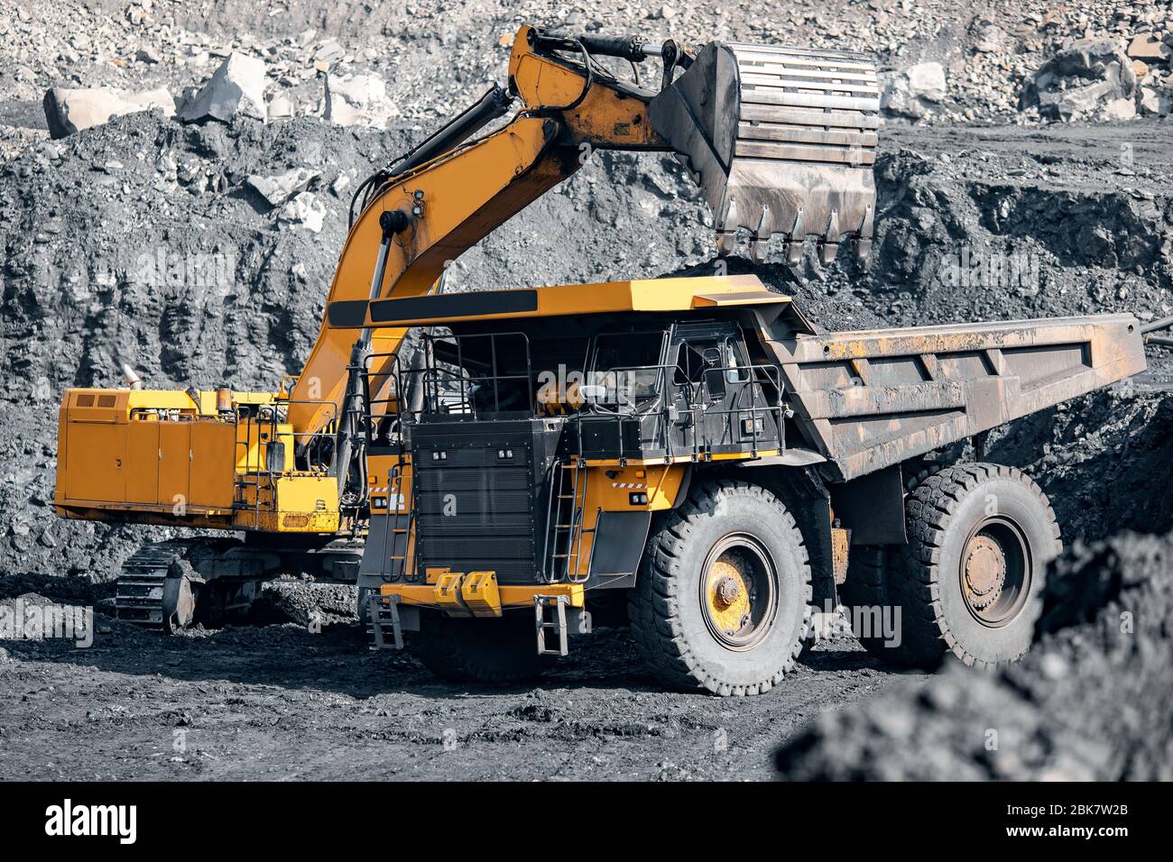 Open pit mine industry. Excavator work loading of coal into Yellow ...