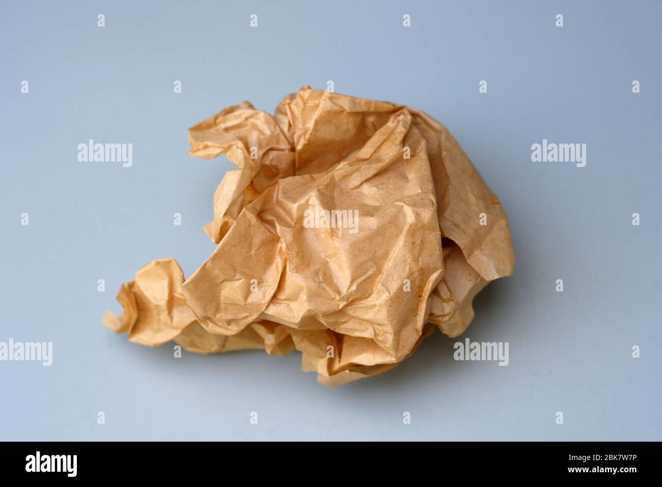 A clump of crumpled paper on a gray background. Crumpled used baking ...