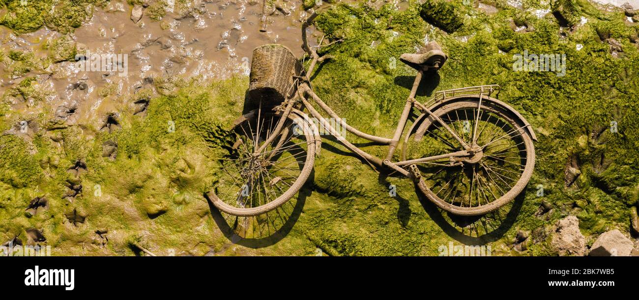 A discarded bicycle with a wicker basket to the canal, a typical ...