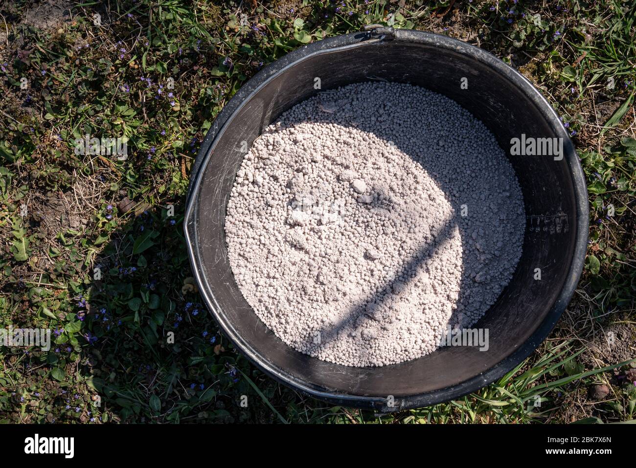Plastic bucket with organic fertilizer in the garden Stock Photo - Alamy