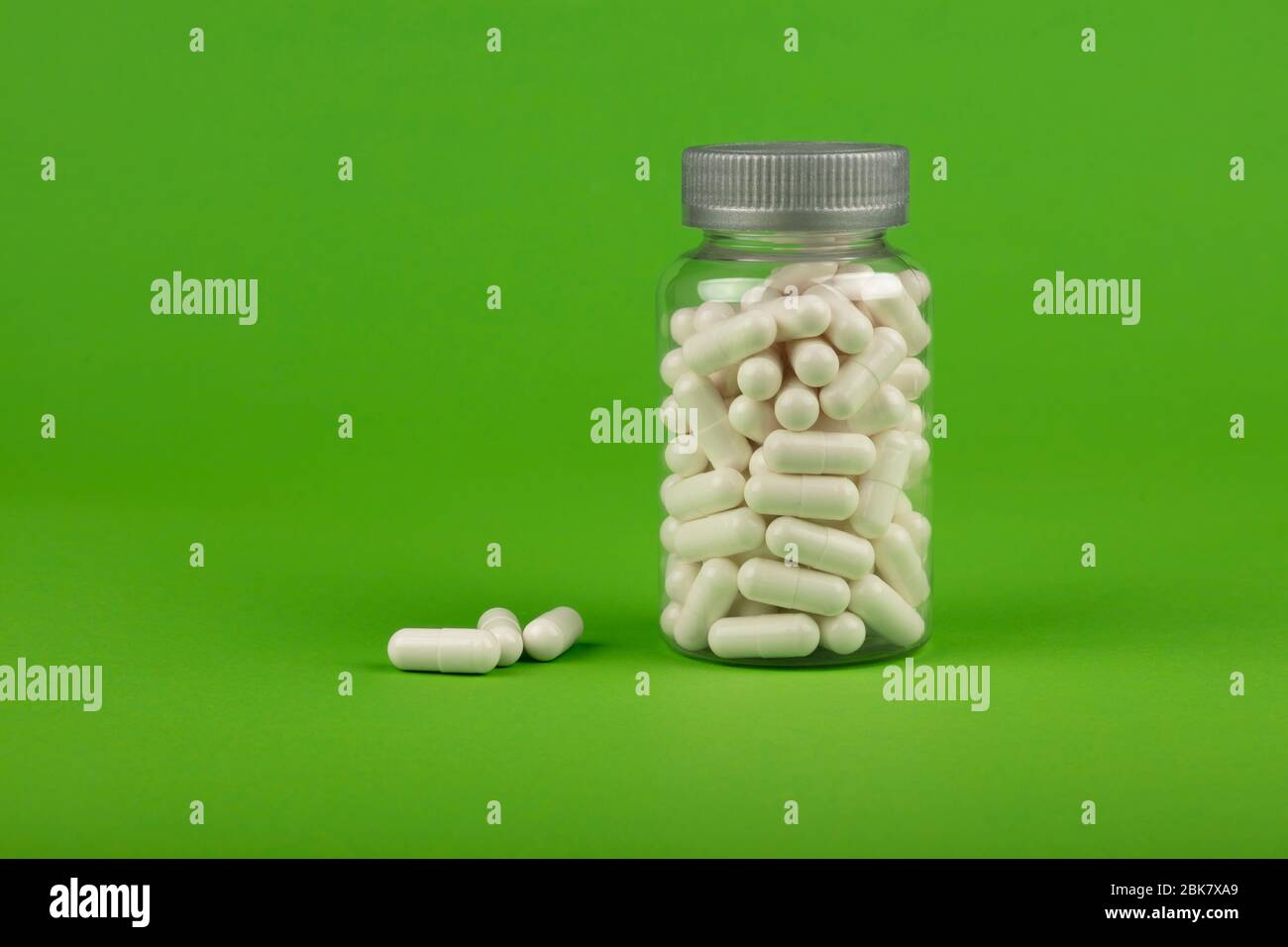 Close up one bottle of white gel cap pills of medicine over natural ...