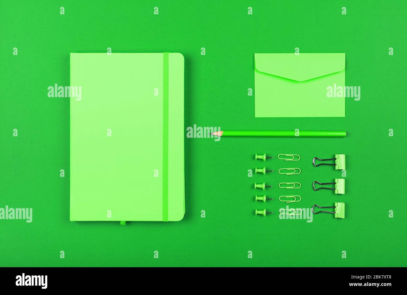 Neatly organized stationery flat lay of pastel green notebook, envelope ...