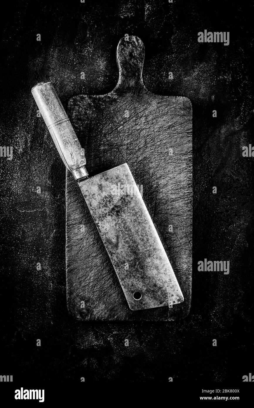 Rustic Meat Cleaver and Cutting Board on Dark Background in Black and ...