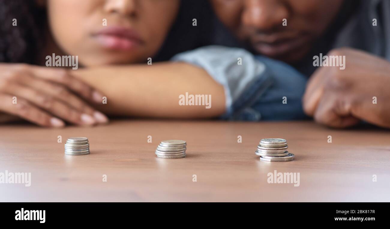 Poverty Concept. Stacks Of Coins Lying In Front Of Sad Black Couple ...