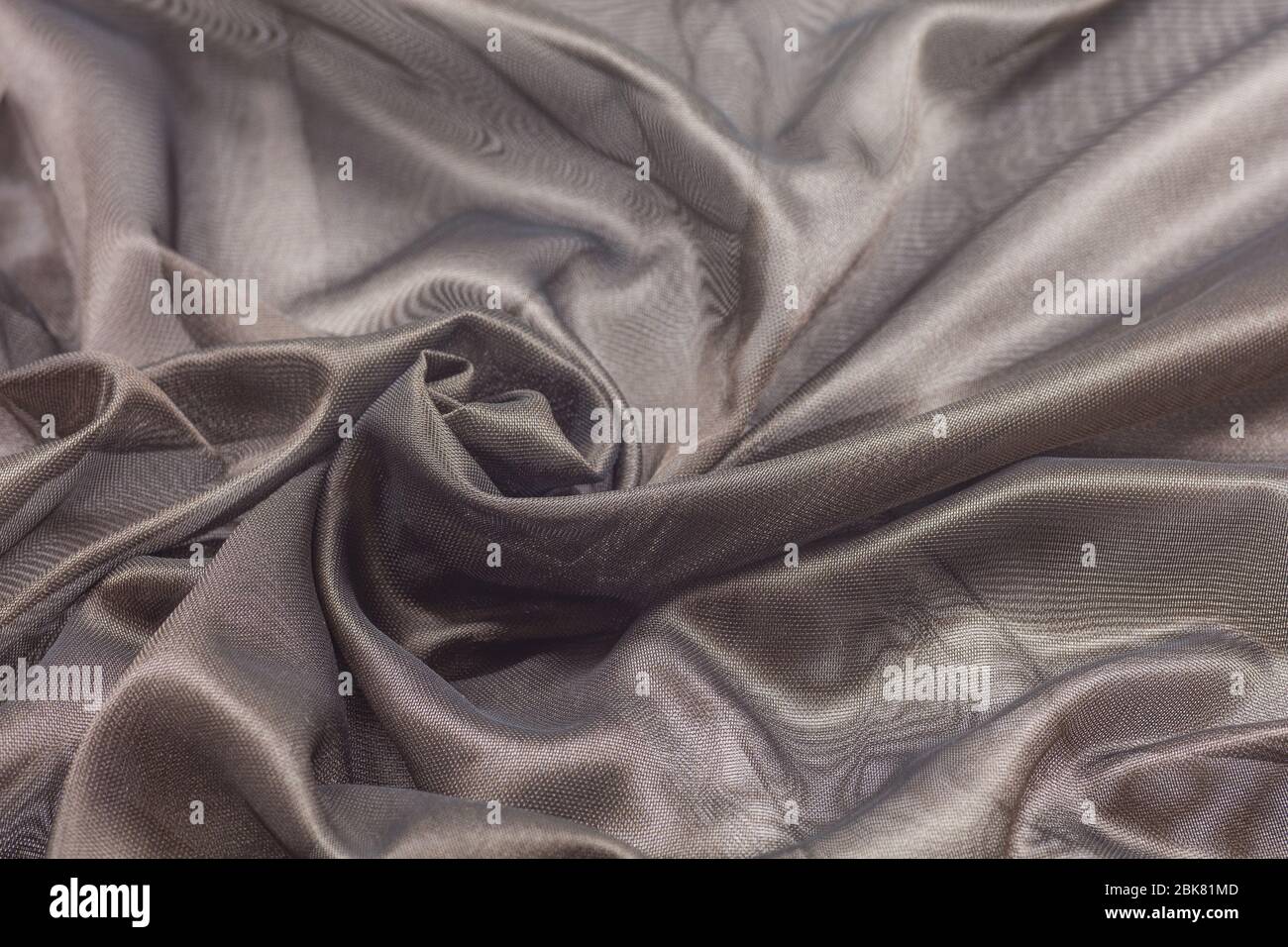 Creased beige curved cloth material fragment with swirl as fabric ...