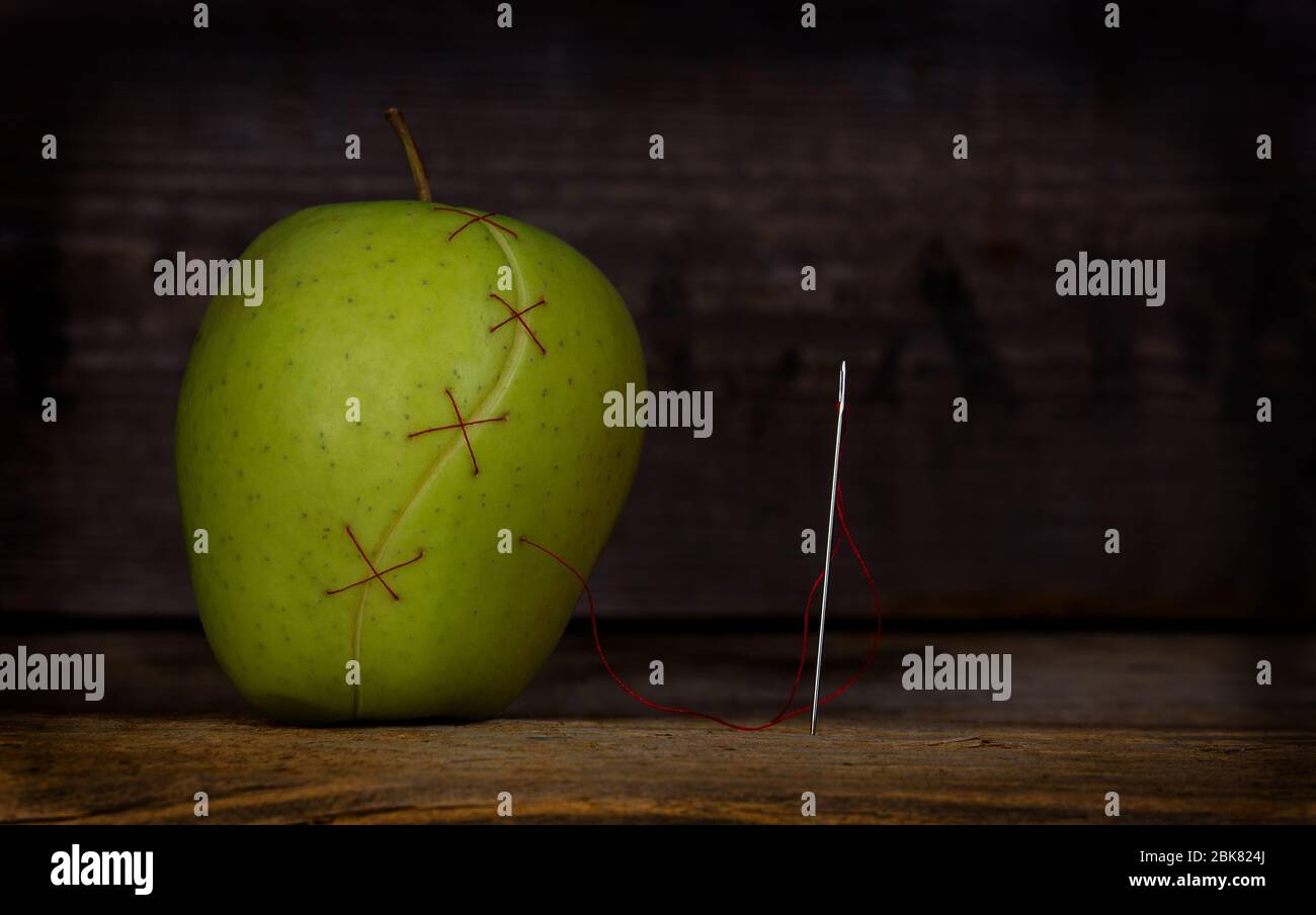 apple stitched together with thread and needle Stock Photo - Alamy