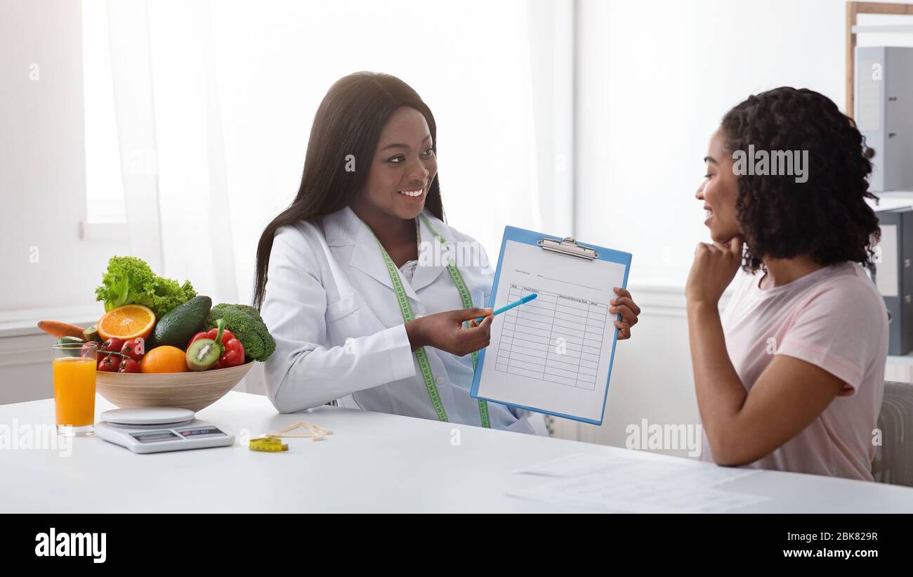 Nutritionist showing patient how to use diet diary Stock Photo - Alamy