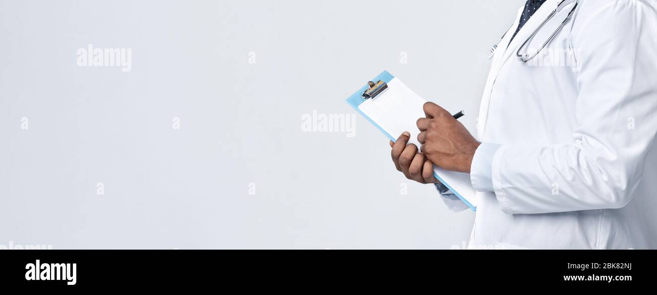 Cropped of black doc filling medical form Stock Photo - Alamy