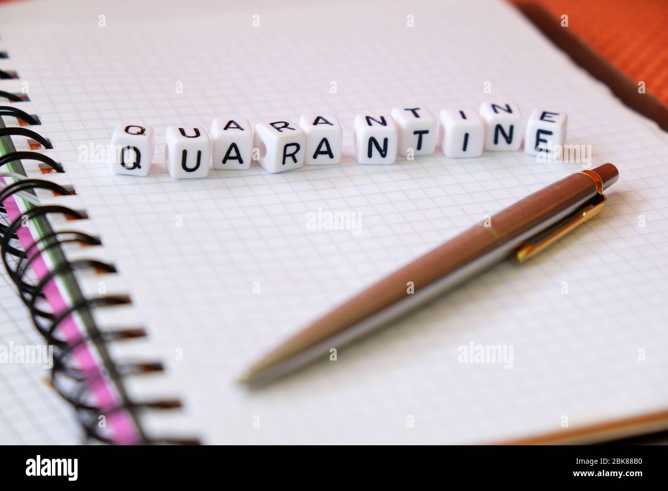 Text "Quarantine", word made of cubic letters and luxury pen on a white ...