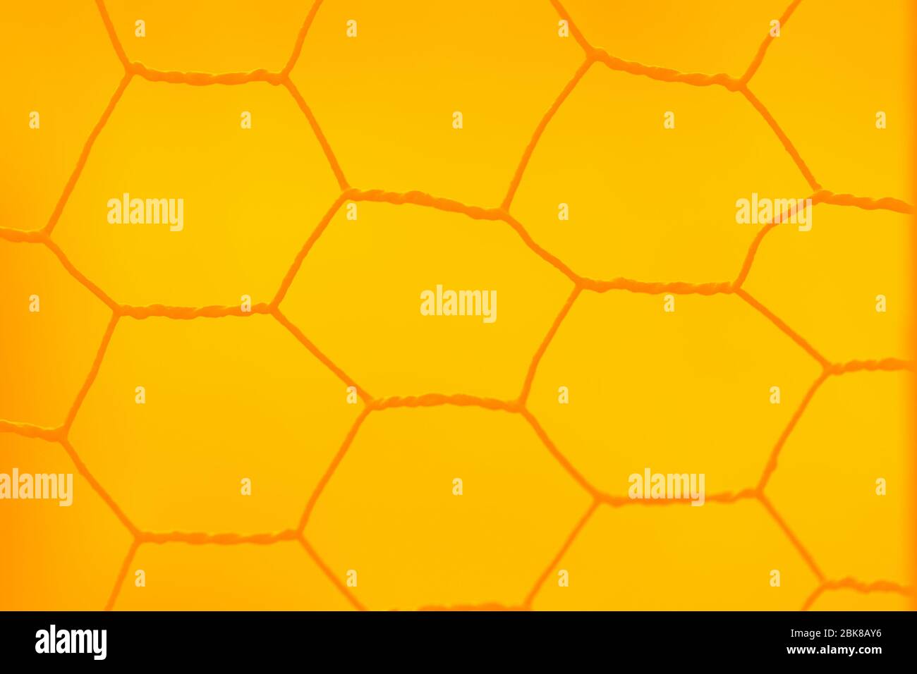 Vivid yellow background with steel fence, mesh pattern Stock Photo - Alamy