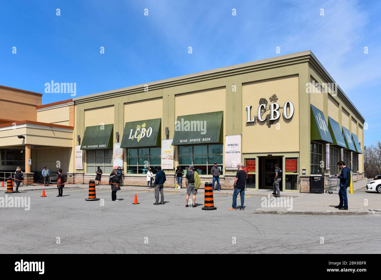 Ottawa, Canada - May 2, 2020: Customers practice social distancing while waiting in line to ...