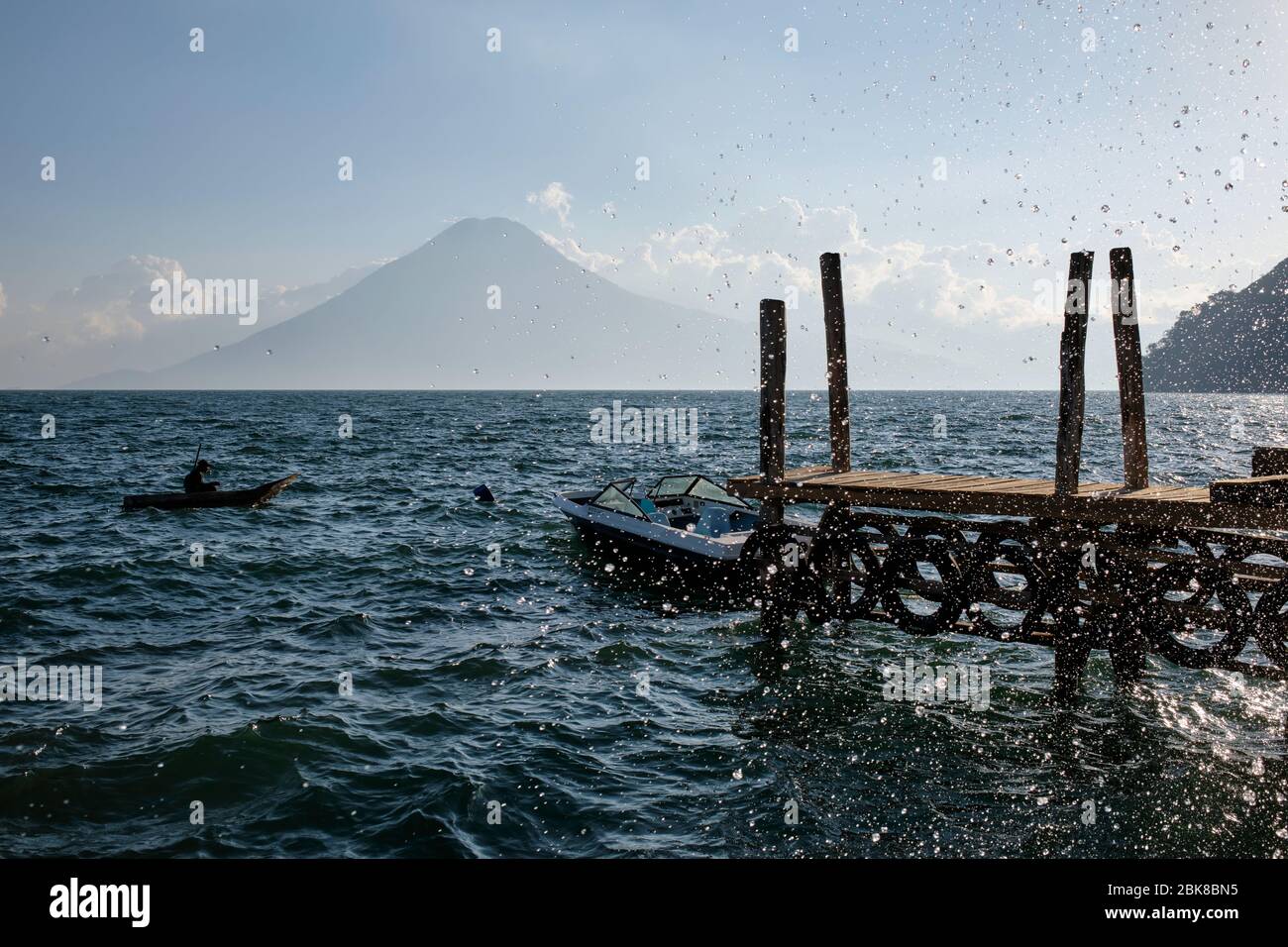 Fisherman in a small boat fishing in Lake Atitlan with views of Atitlan ...