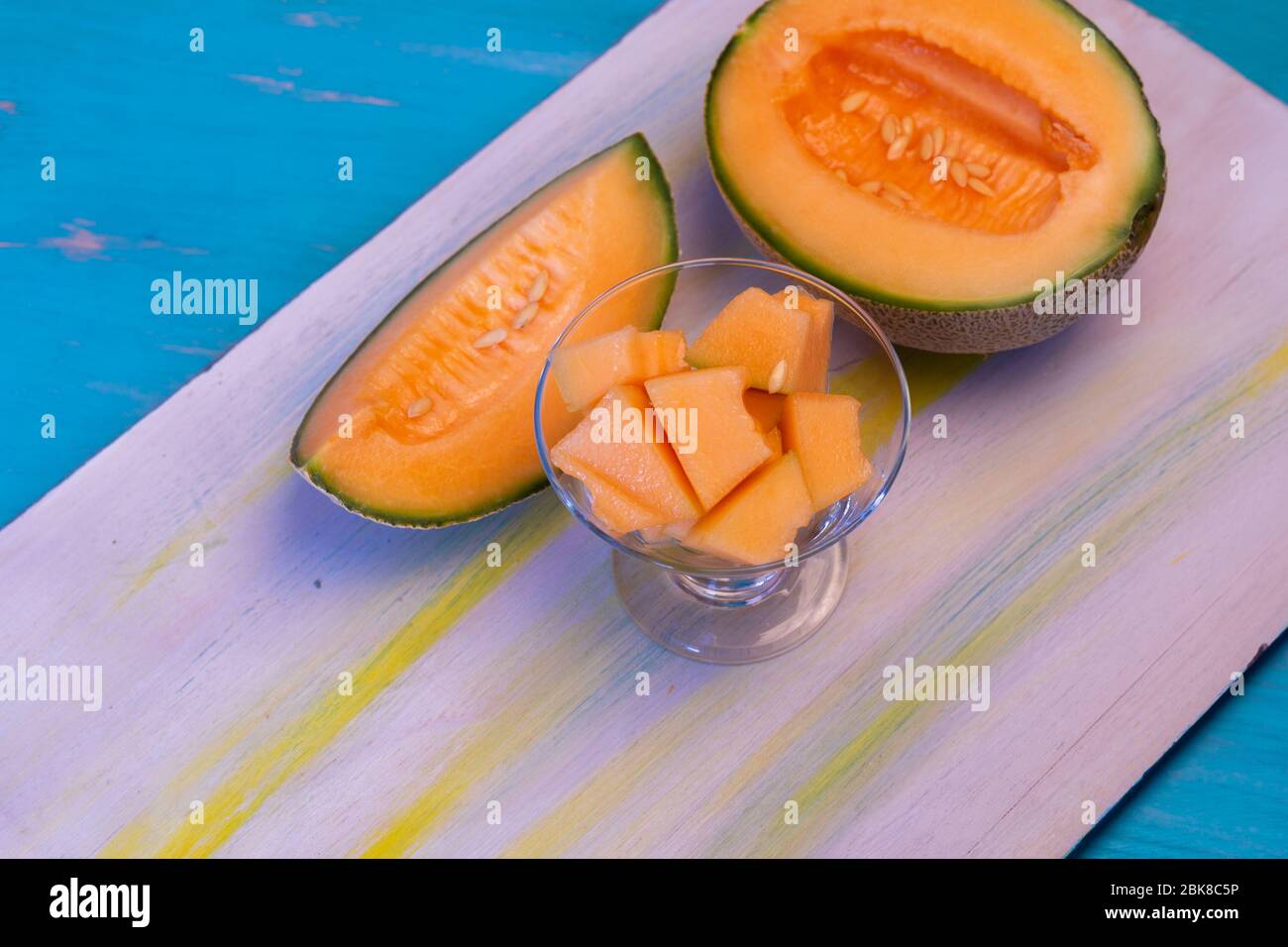Melon pieces, on white table Stock Photo - Alamy
