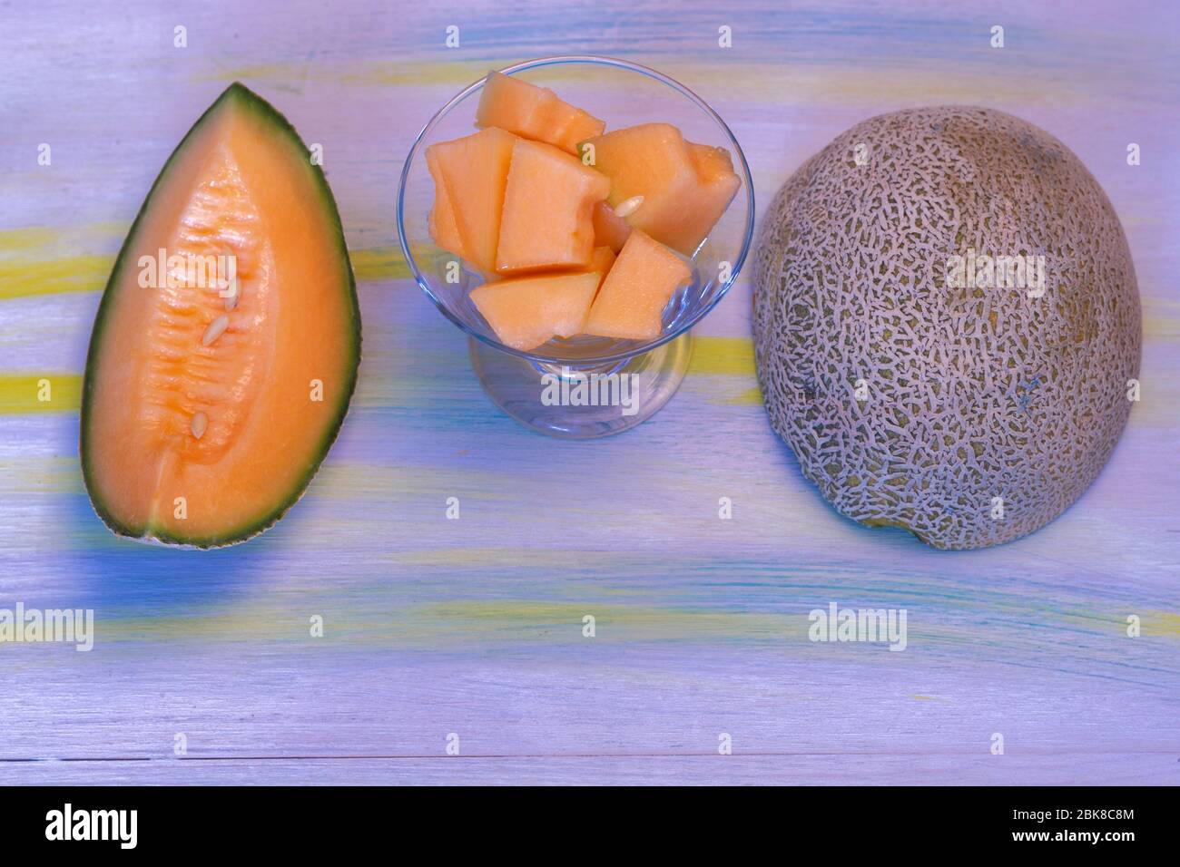 Melon pieces, on white table Stock Photo - Alamy