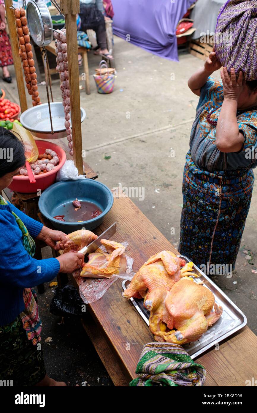 Woman dressed with traditional colourful clothes buying chicken in a ...