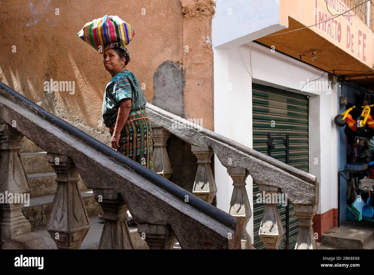 Woman dressed with colourful indigenous clothes carrying a load on her ...