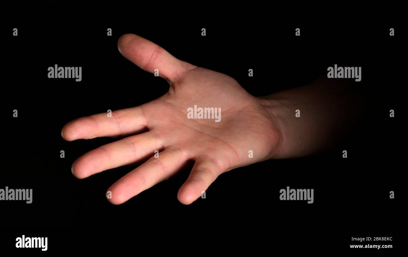 Human male palm clench a fist isolated on black background. Close up ...