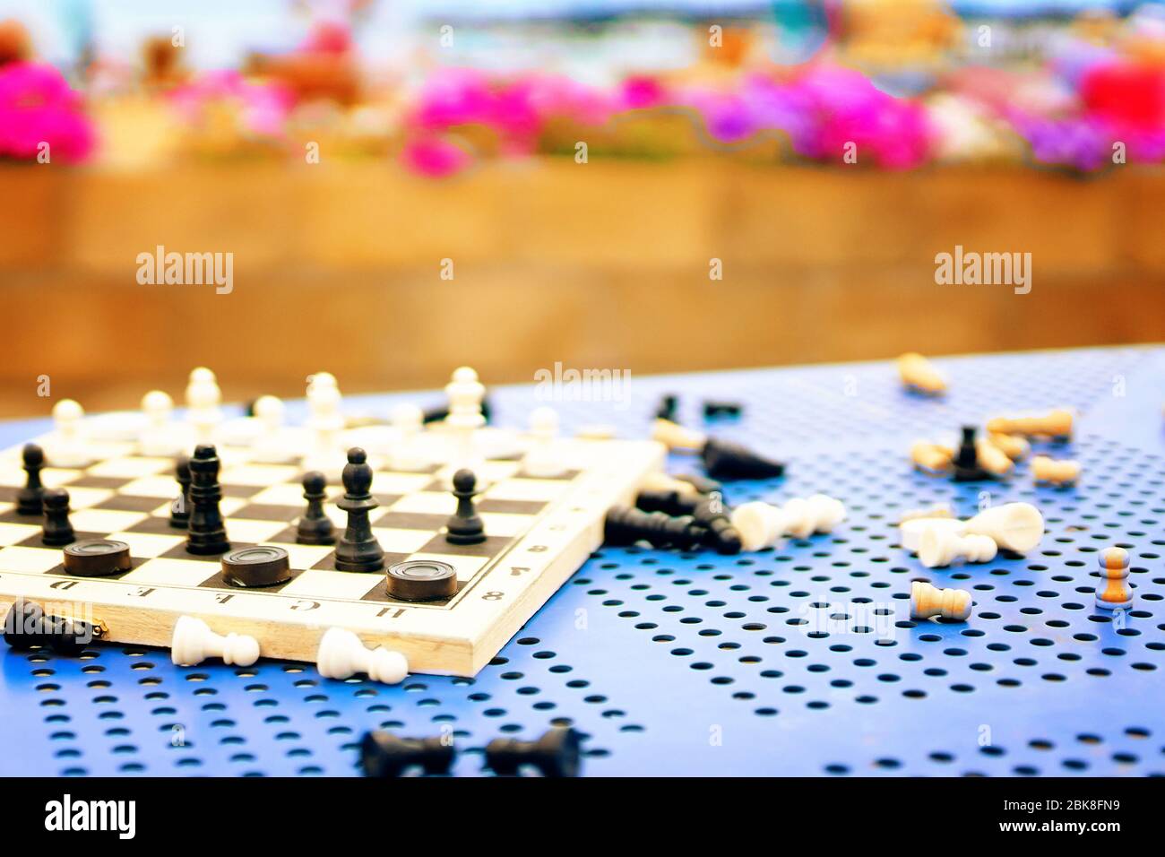 Scattered chess on a board table in the park. Empty sports fields due ...