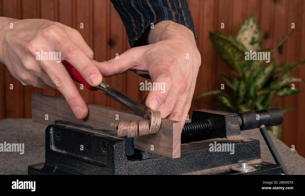 closeup scene of hands of a male wood worker, shaping wooden plank with ...