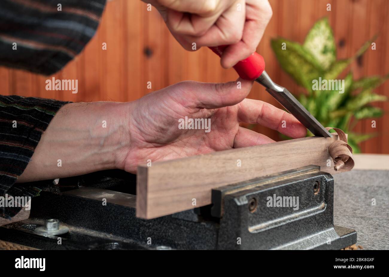 a closeup opposite angle scene of hands of a male carpenter, planing ...