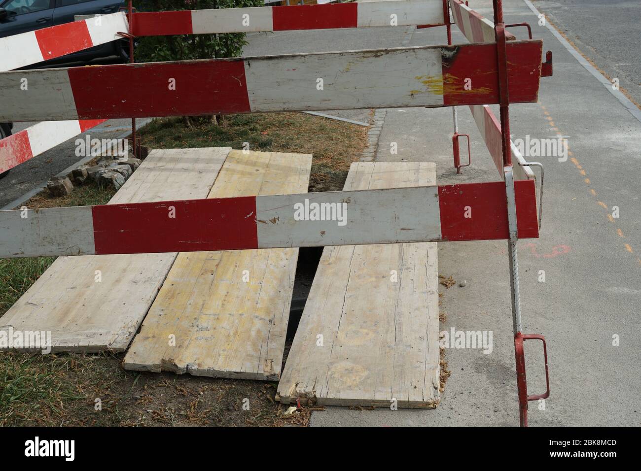 small civil engineering shaft covered by wooden planks, border by a ...
